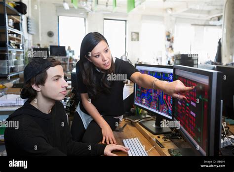 Man And Woman Examining Circuits On Computer Monitors Stock Photo Alamy