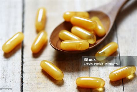 나무 숟가락과 나무 테이블 배경에 로얄 젤리 캡슐 건강을위한 자연에서 노란색 캡슐 의학 또는 보충 식품 영양제에 대한 스톡 사진 및 기타 이미지 Istock