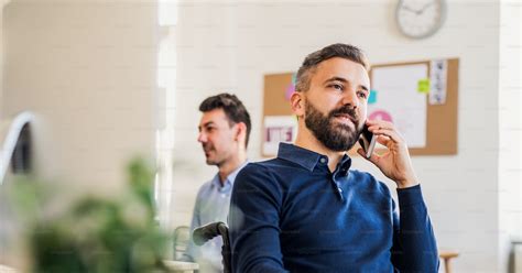 휠체어를 탄 젊은 사업가가 스마트폰을 들고 현대적인 사무실에서 일하며 전화를 걸고 있다 사진 Unsplash의 복사 공간 이미지