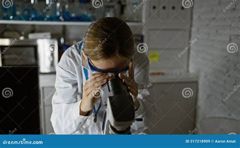 Woman Scientist Using Microscope In A Laboratory Setting Reflecting