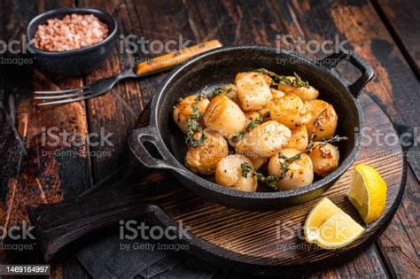 가리비는 마늘 백리향 버터에 그을려 주철 프라이팬에 담겨 있습니다 나무 배경입니다 상위 뷰 가리비에 대한 스톡 사진 및 기타 이미지 Istock
